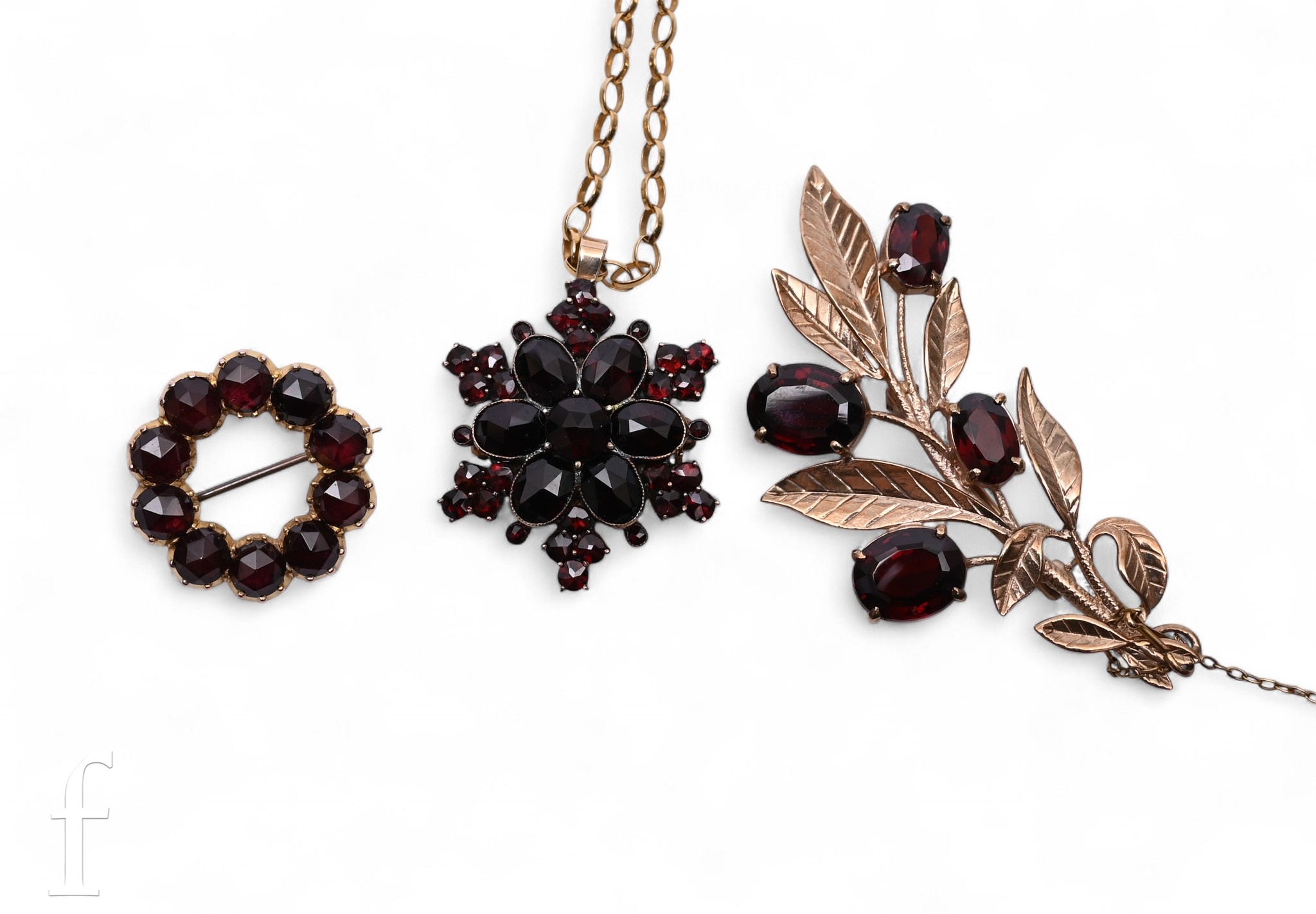 A garnet pendant brooch, the flower head set with a circular mixed-cut ...
