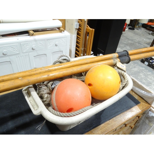A Pair Of Boat Oars Together With A Box Of Buoys