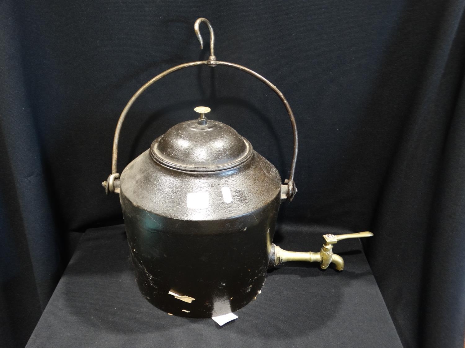 An Antique Cast Iron Boiler With Brass Tap