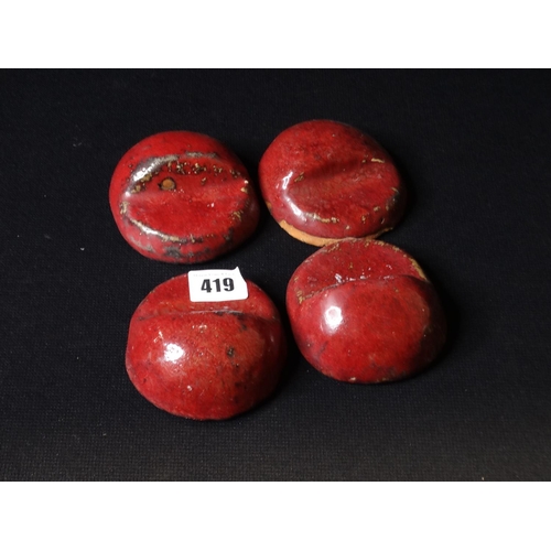 A Set Of Four Red Ceramic Window Stops