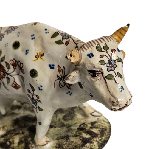 A PAIR OF VINTAGE CONTINENTAL FAIENCE POTTERY COWS Cow and bull with ...