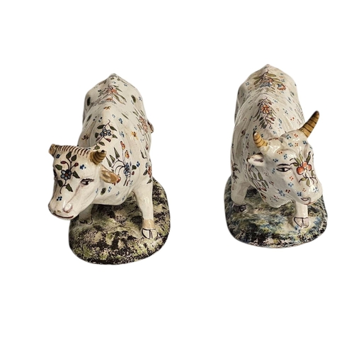 A PAIR OF VINTAGE CONTINENTAL FAIENCE POTTERY COWS Cow and bull with ...