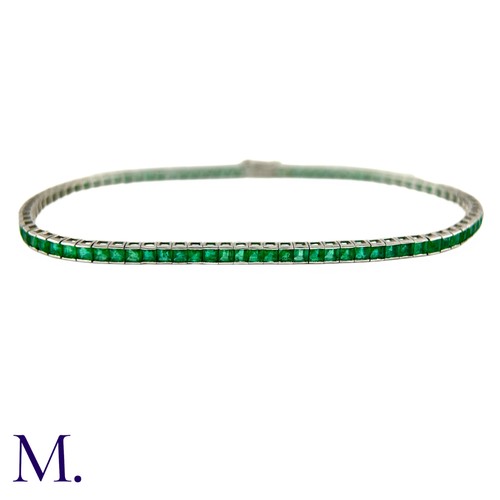 An Emerald Line Bracelet. The 18ct white gold bracelet is set with ...