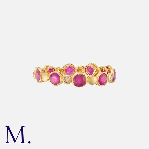 A Ruby And Diamond Eternity Ring in yellow gold, comprising an alternating row of bezel set rubies a