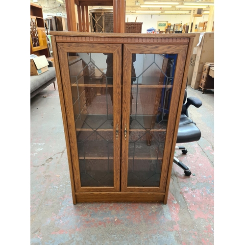 A modern oak effect bookcase with two glazed doors and four internal ...