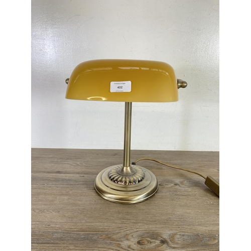 A brass effect and amber glass bankers style desk lamp - approx. 34cm high