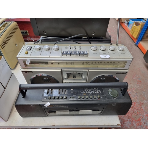 Two portable stereo radio cassette players, one Bush SRC261 and one ...