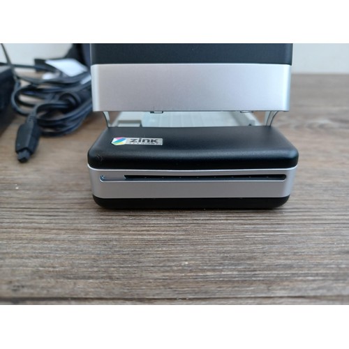 A cased Polaroid CZA-10011B PoGo instant mobile photo printer with ...