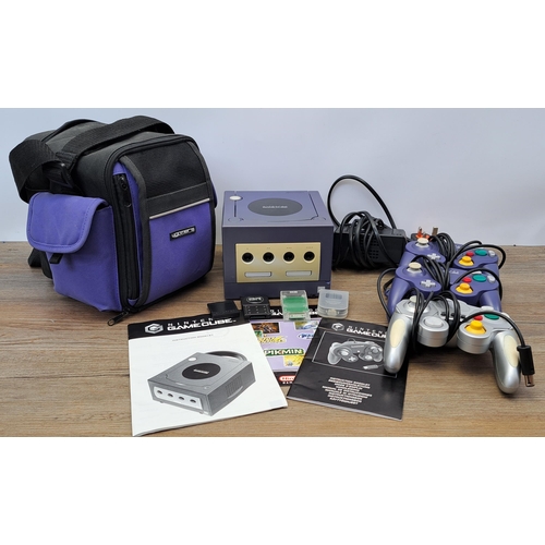 A Nintendo Gamecube console with three controllers and carry case