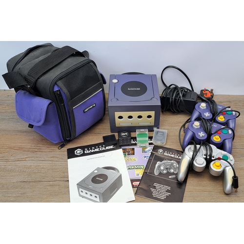A Nintendo Gamecube console with three controllers and carry case