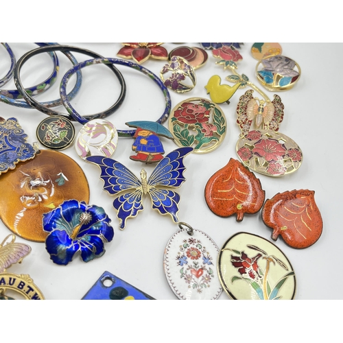 A collection of enamel jewellery to include brooches, bangles etc.