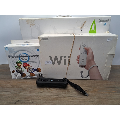 A boxed Nintendo Wii console with boxed Wii Fit unit, Wii Motion Plus ...