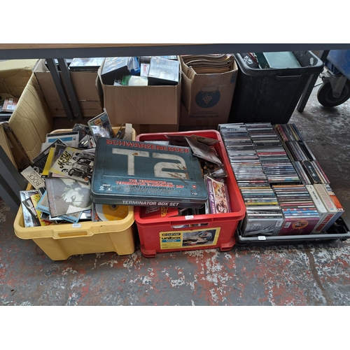 Four boxes containing a collection of CDs and DVDs