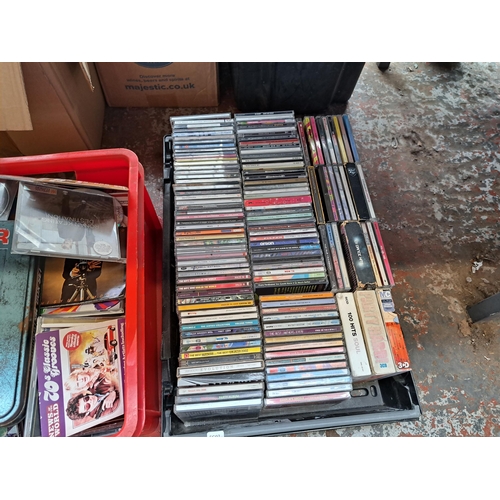 Four boxes containing a collection of CDs and DVDs