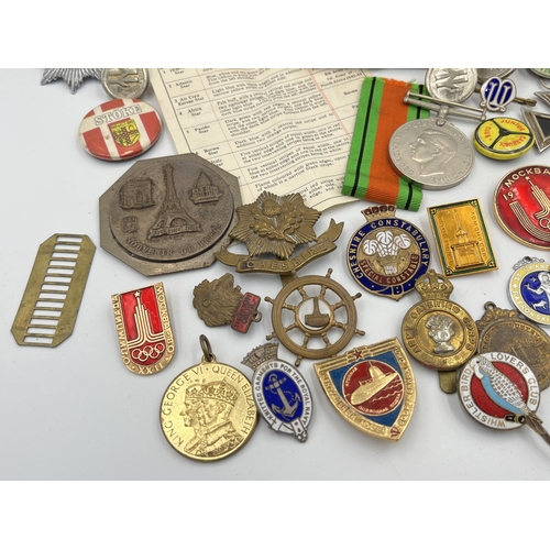 A collection of medals and badges to include boxed WWII Defence medal ...