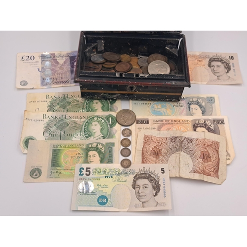 A vintage change tin containing a collection of British banknotes and ...