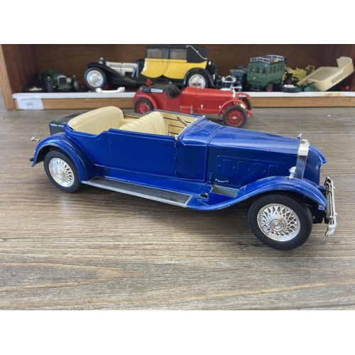 A wooden wall hanging display cabinet with a collection of diecast ...