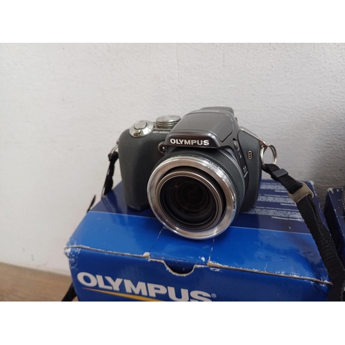 Two boxed Olympus compact digital cameras with software discs, xD ...