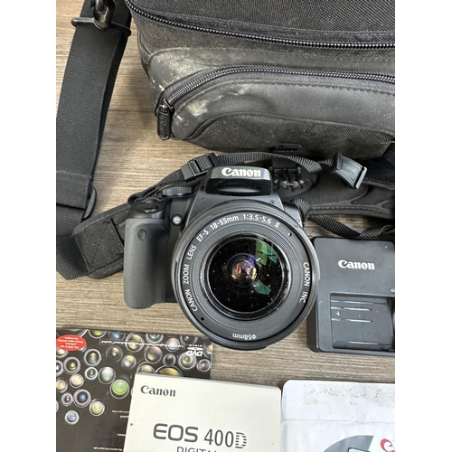 Two cased Canon EOS DSLR cameras fitted with EF-S zoom lenses, one 400D ...