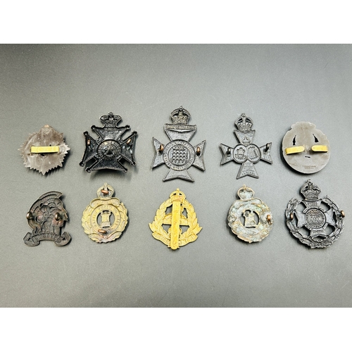 Ten military cap badges