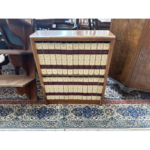 A mid 20th century walnut bookcase containing 24 volumes of ...
