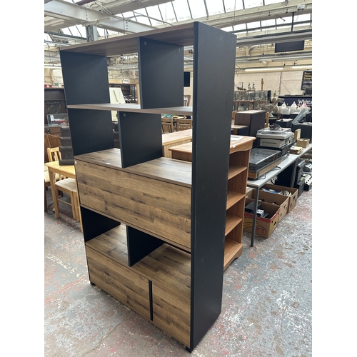 A Next Dark Bronx oak effect and black laminate display desk/open ...