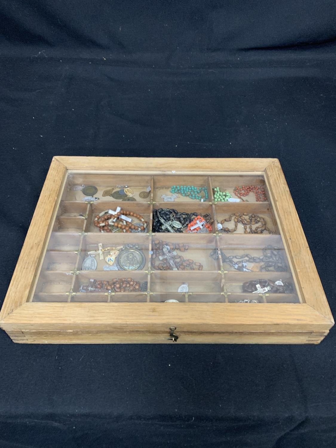 Display case of rosaries and St. Christopher's