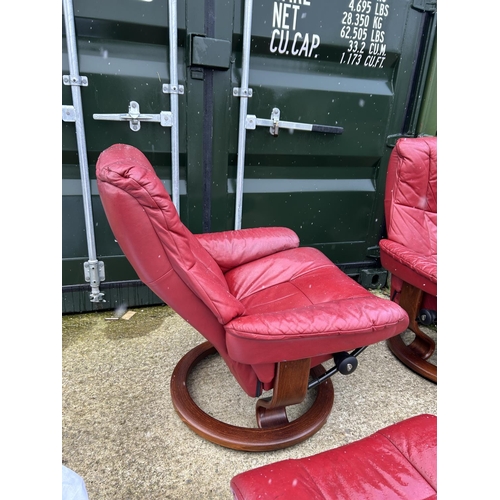 A pair of EKORNES red leather reclining chairs with matching footstools
