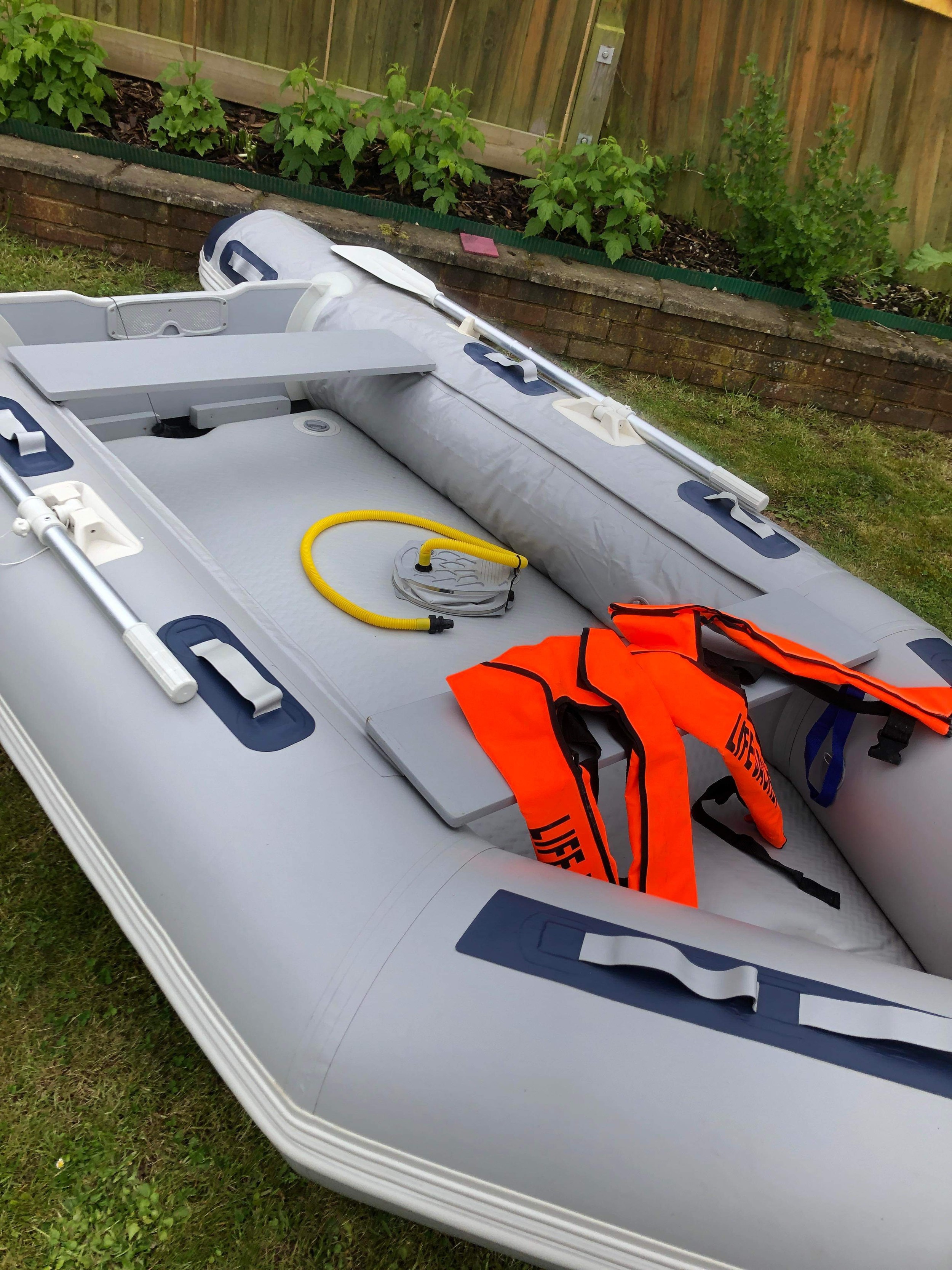 A grey inflatable dinghy boat with carry case