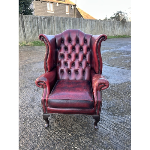 A red leather chesterfield wing back chair for restoration