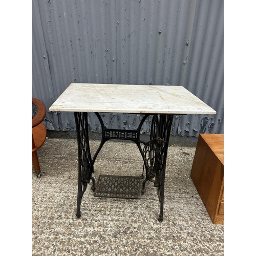 A iron based singer sewing machine base with white marble top 76x50x74