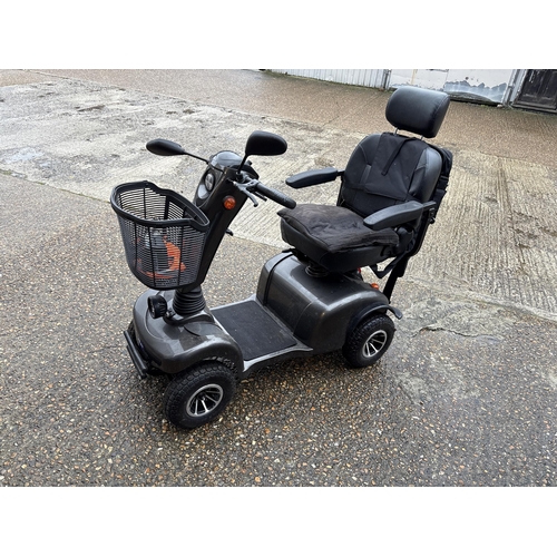 A large 'ability plus' black mobility scooter with key and charger