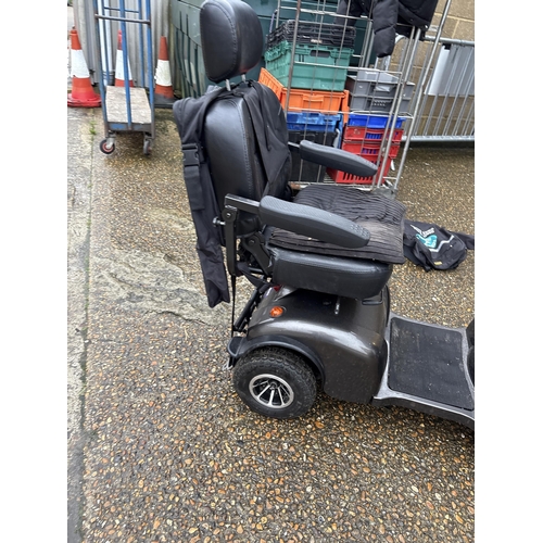 A large 'ability plus' black mobility scooter with key and charger