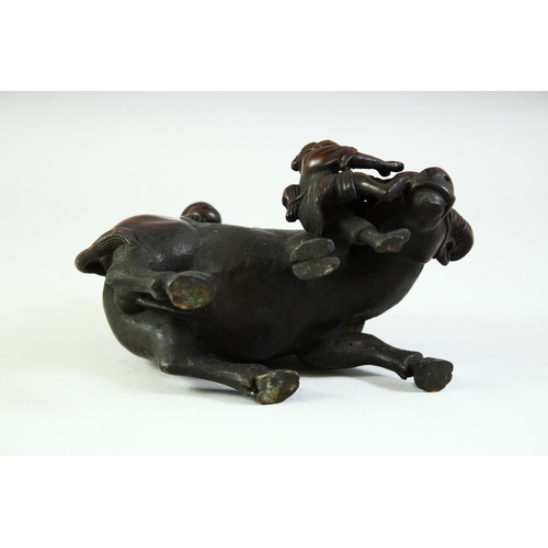 A CHINESE BRONZE MODEL OF AN OXEN, with two young boys upon it, 16.5cm ...