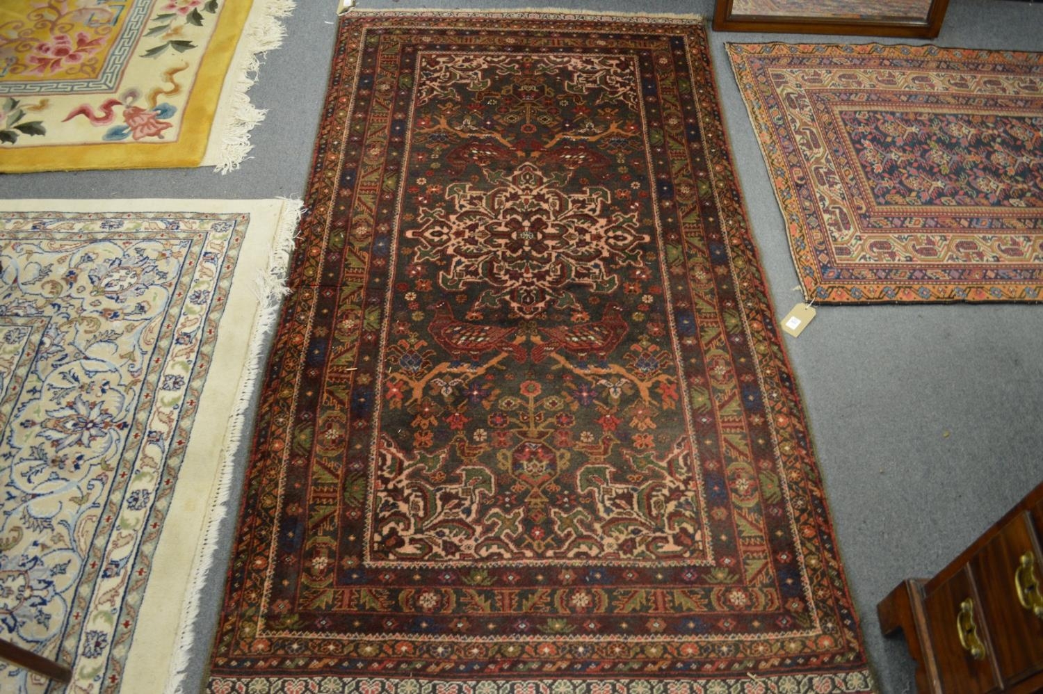 A Persian rug, decorated with birds and flowers 200cm x 110cm.