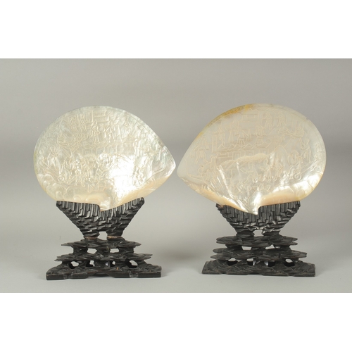 A PAIR OF CHINESE CARVED MOTHER OF PEARL SHELLS on fitted carved wood ...