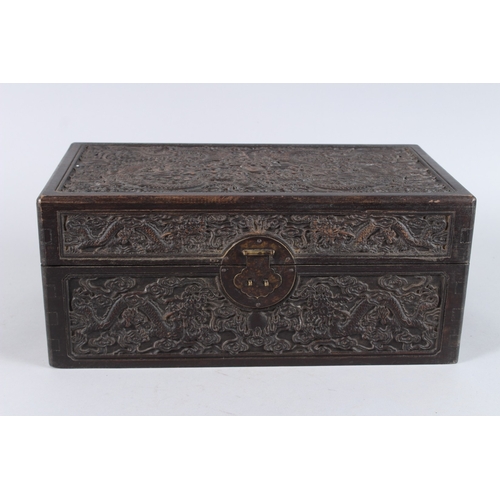 A CHINESE CARVED WOOD CASKET, with hinged cover, carved to the top ...