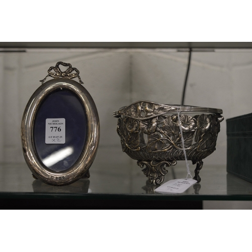 A small silver oval photograph frame and a plated basket with glass liner.