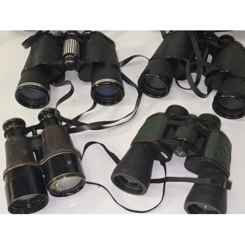 A collection of four pairs of binoculars. Two pairs have cases.