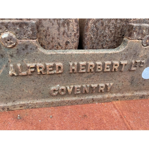 A VINTAGE CAST IRON CART WHEEL BEARING THE NAME 'ALFRED HERBERT LTD'