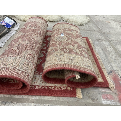 TWO SMALL RED PATTERNED FRINGED RUGS