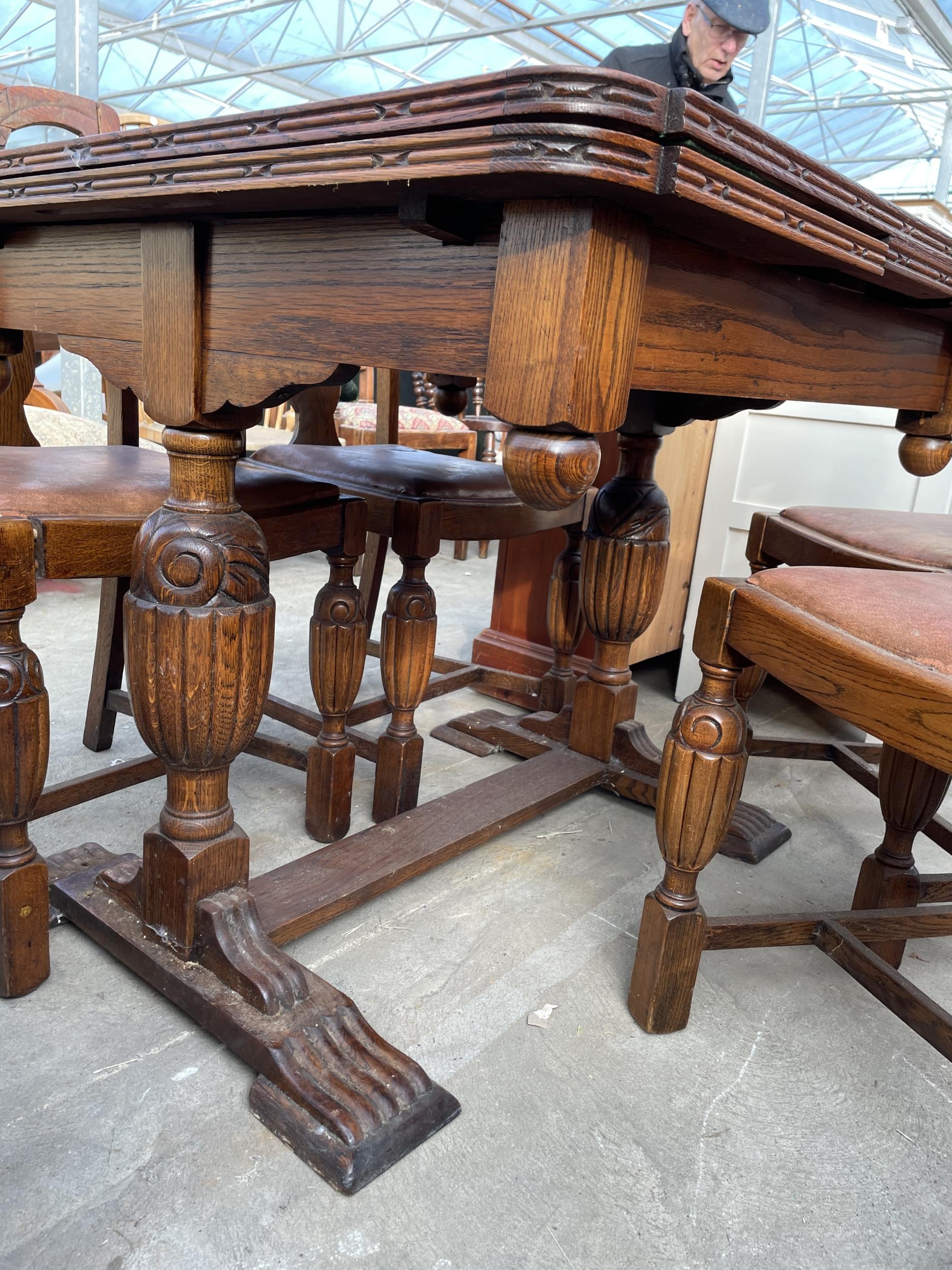 AN EARLY TWENTIETH CENTURY OAK DRAW LEAF DINING TABLE ON PEDESTAL BASE AND FOUR CHAIRS