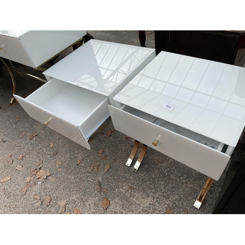 A WHITE DRESSING TABLE ON X FRAME LEGS AND A PAIR OF MATCHING BEDSIDE ...