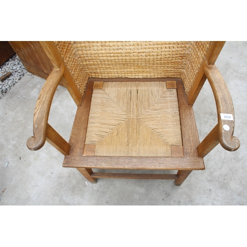 A HOODED OAK FRAMED ORKNEY CHAIR WITH WICKER SEAT AND STITCHED STRAW ...