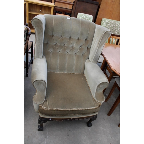 A GEORGIAN STYLE WINGED EASY CHAIR ON CABRIOLE LEGS WITH BALL AND CLAW FEET