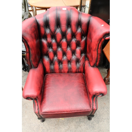 AN OXBLOOD BUTTON-BACK WINGED EASY CHAIR ON FRONT CABRIOLE LEGS