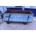 A VINTAGE FOUR WHEELED RAILWAY CART BERARING THE NAME HOCKNELLS ...