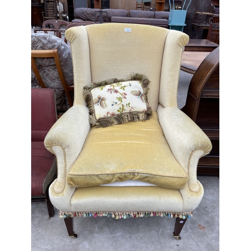 A 19TH CENTURY STYLE WINGED LOUNGE CHAIR ON TAPERING LEGS BY THE ODD ...