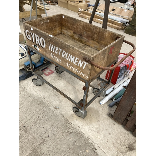 A VINTAGE MONOGRAMED GYRO BOX WITH METAL FOUR WHEELED TROLLEY BASE