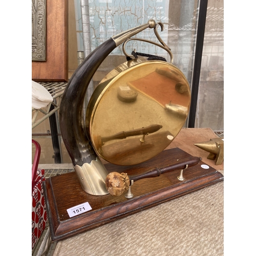A BRASS TABLE TOP GONG WITH COW HORN STAND AND STRIKER